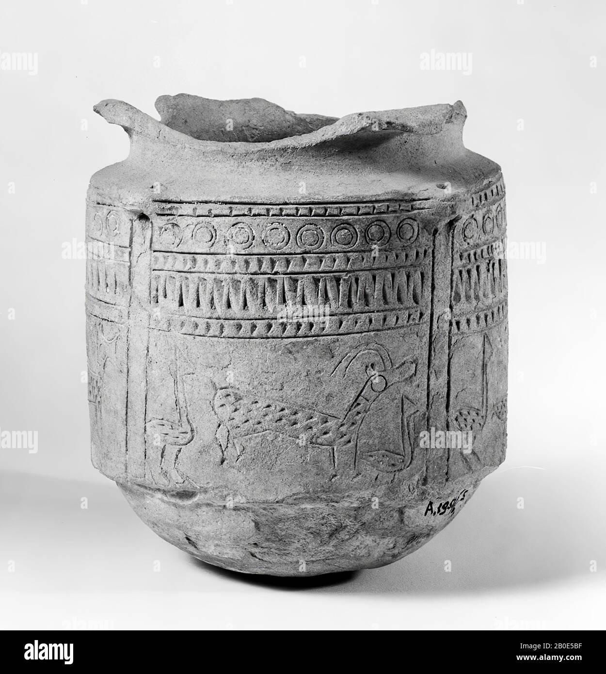 Cylindrical pot of gray earthenware, decorated with incised compartment ...