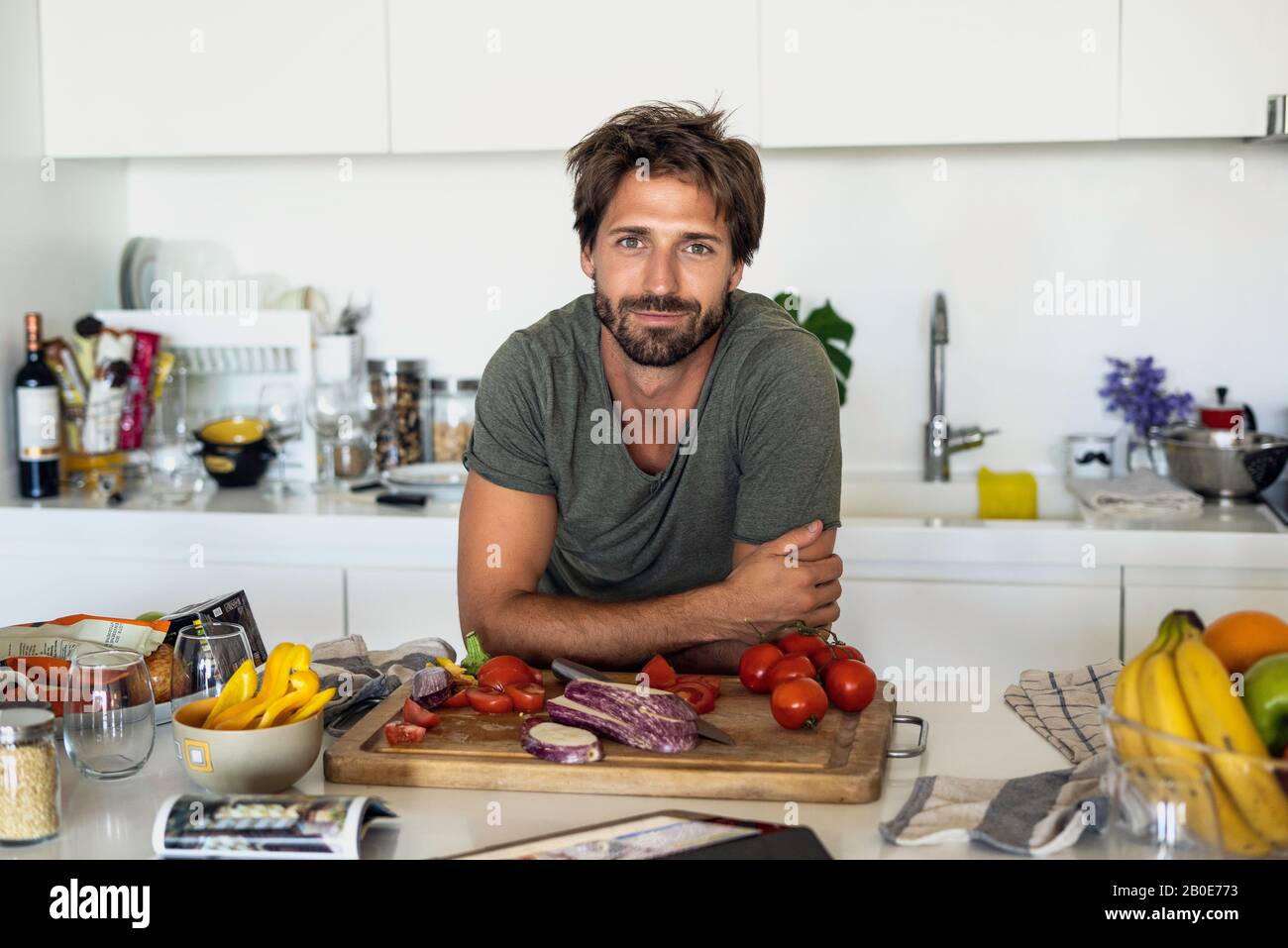 Young man in kitchen with arms crossed hi-res stock photography and ...