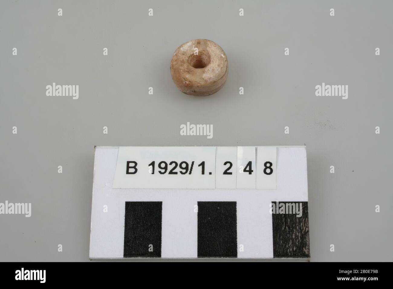 A cylinder shaped stone with a biconcavered hole, spider stone, bead ...