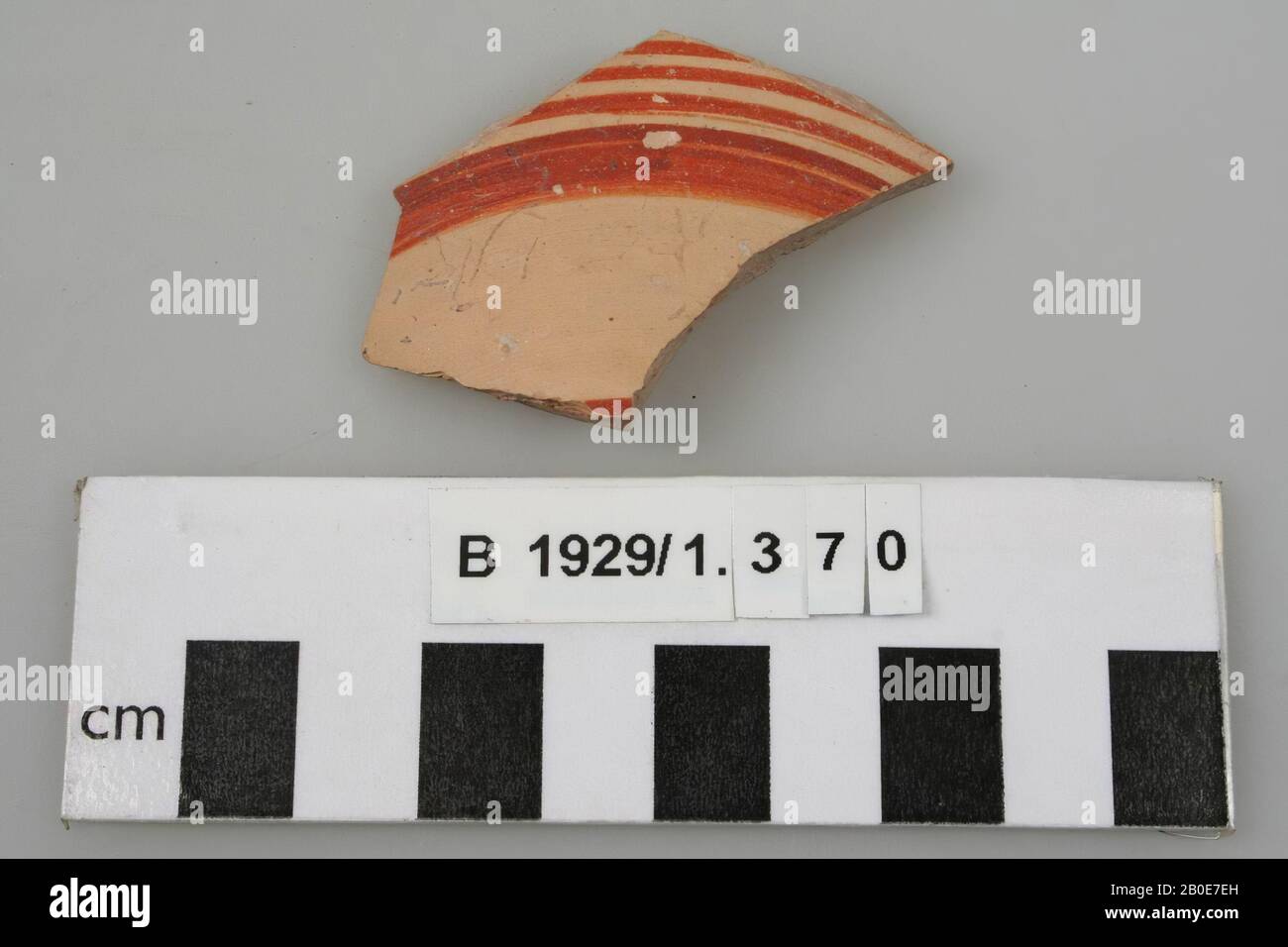 A wall shard of a jug, decorated with orange-brown paint. Probably ...