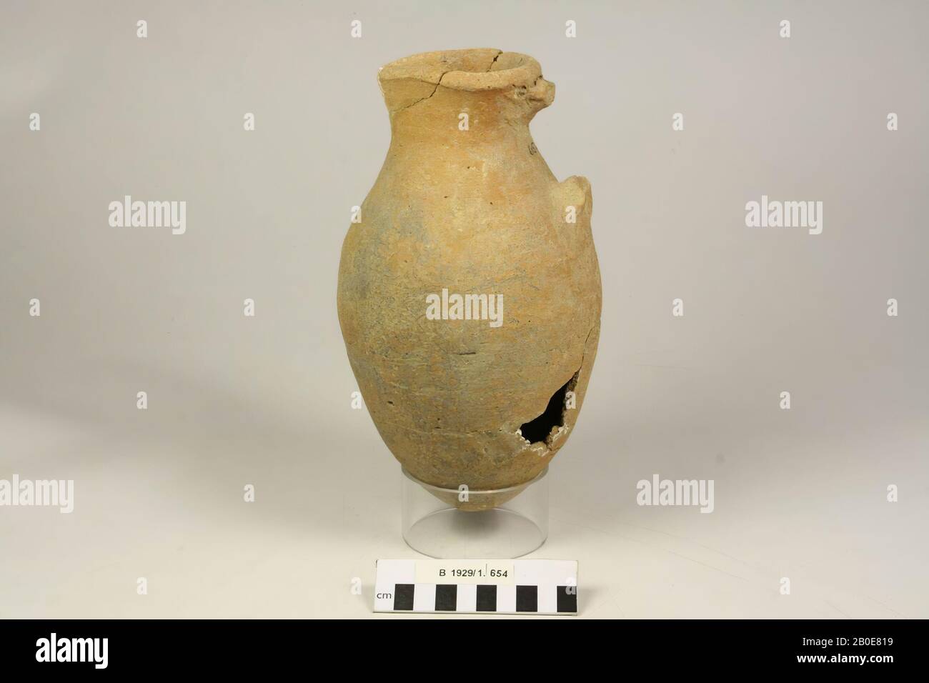 A jug with a point bottom and one ear. The ear is missing and the rim ...