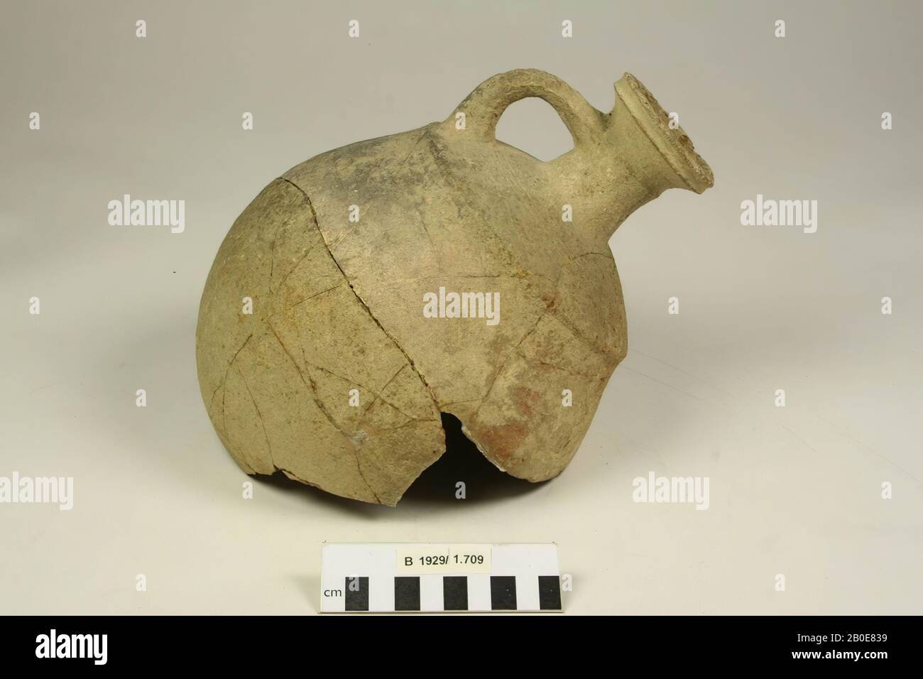 A large fragment of an earthenware jug with one ear. The jug leaves a ...