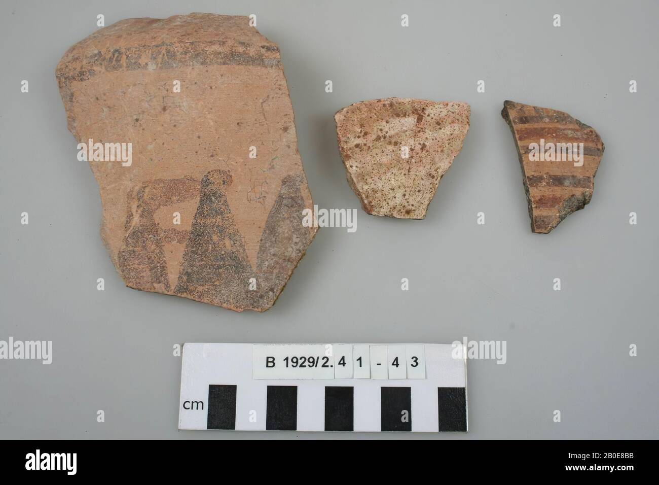 A wall shard of a jug. The exterior is decorated with red and black ...