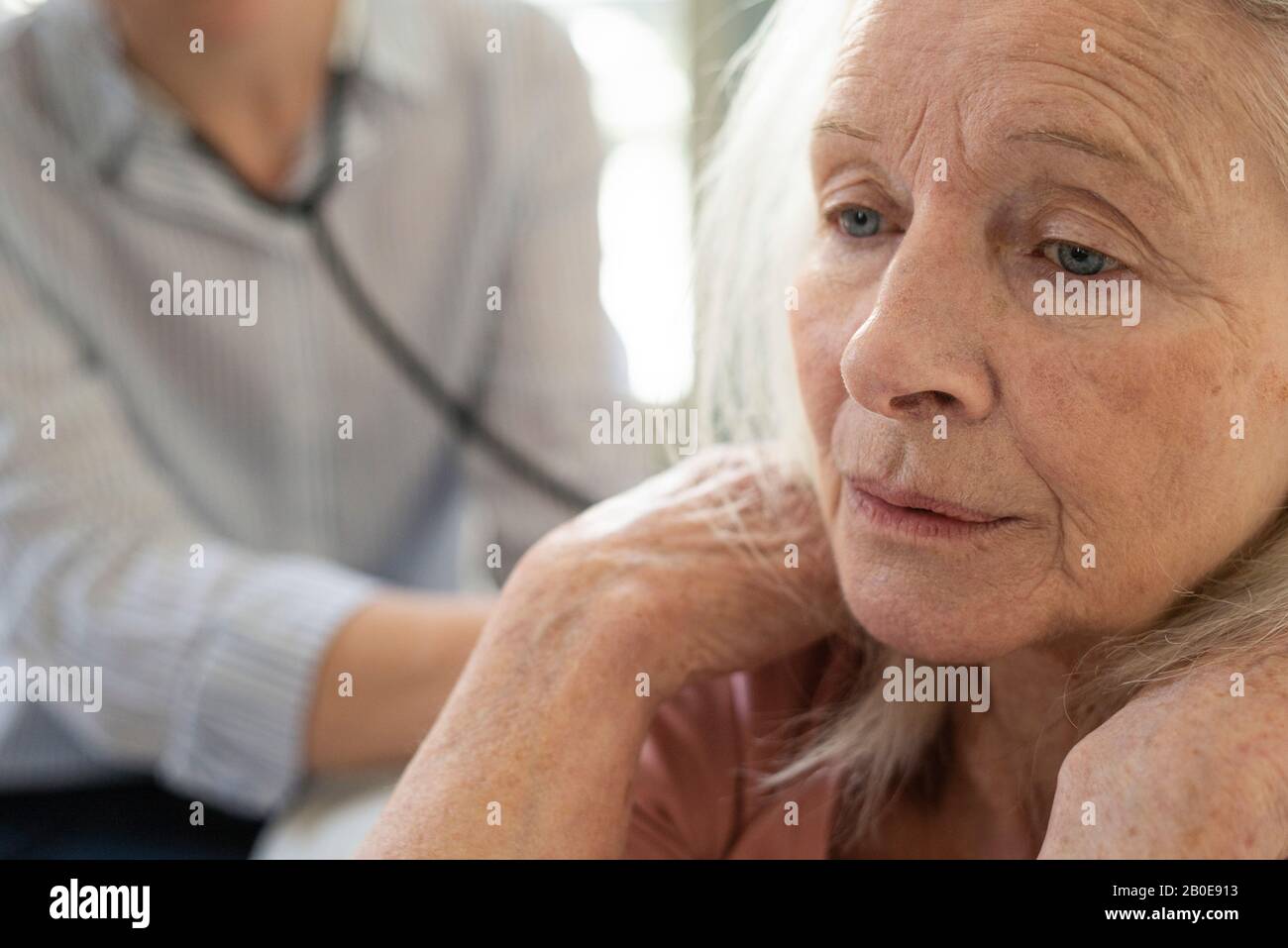 Home carer examining back of senior woman Stock Photo - Alamy
