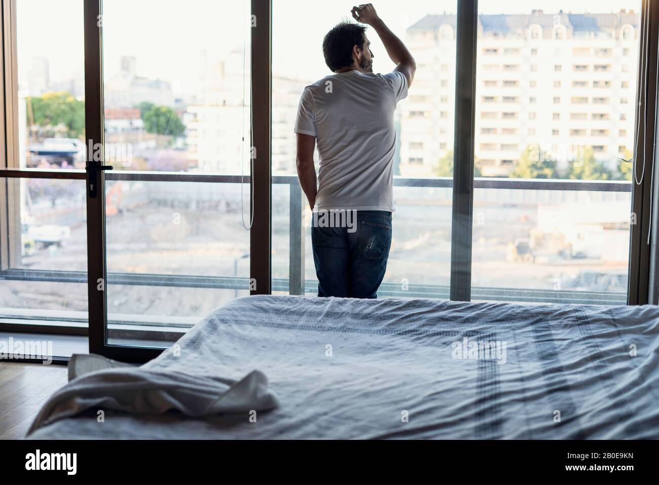Young man standing by the window Stock Photo - Alamy
