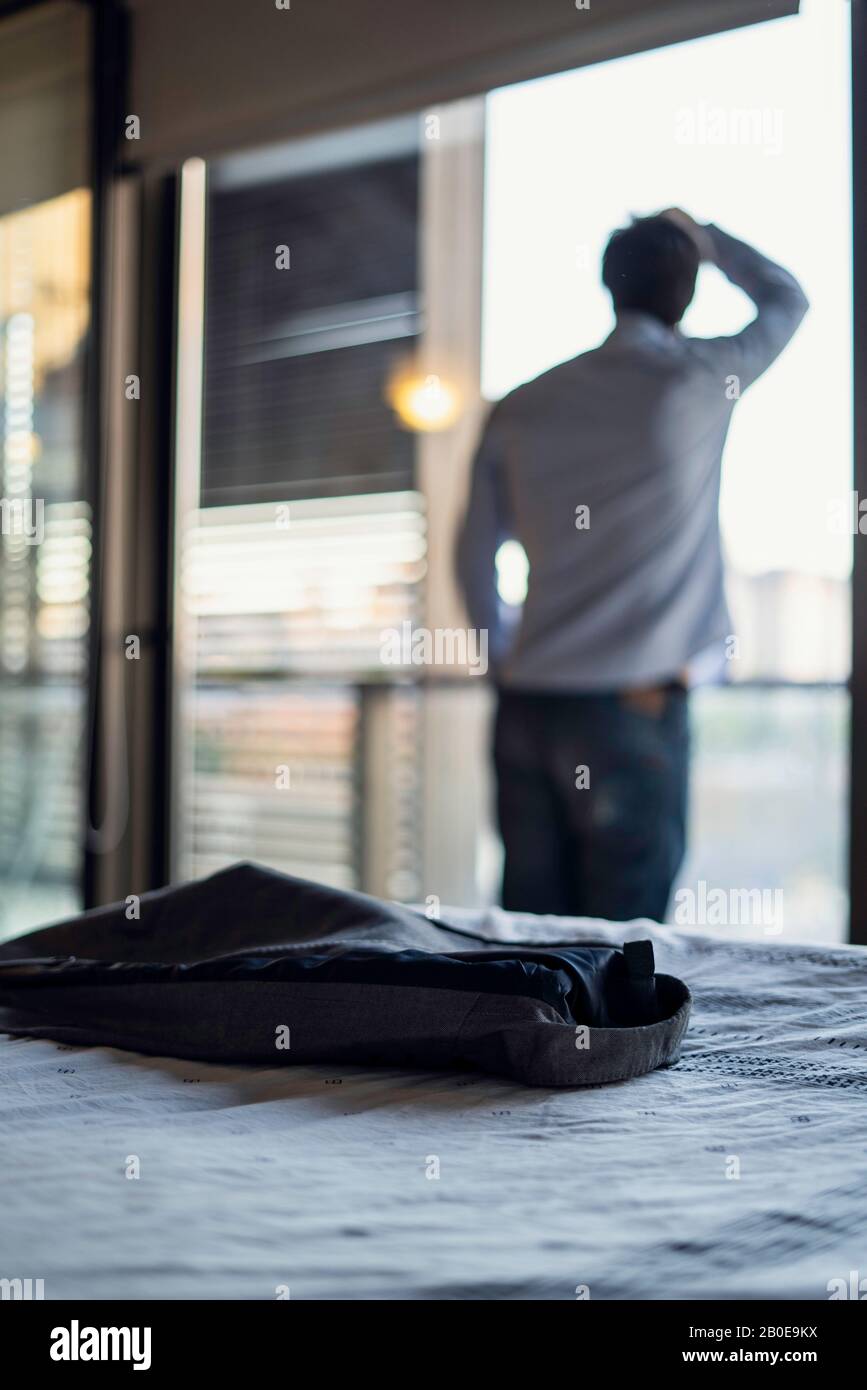 Thoughtful young man standing by the window Stock Photo - Alamy