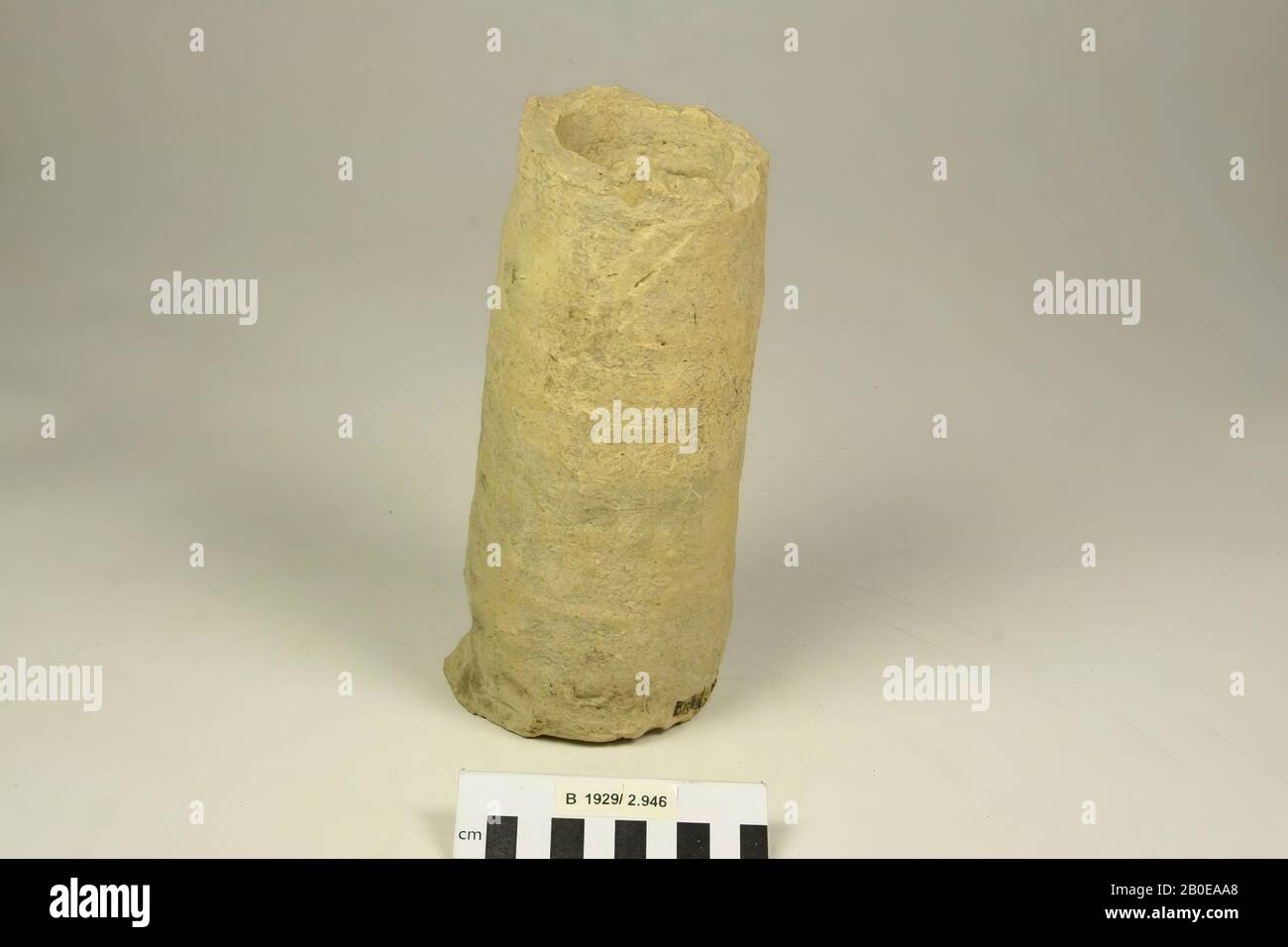 An earthenware jug with flat bottom and tubular body. Rand is missing ...