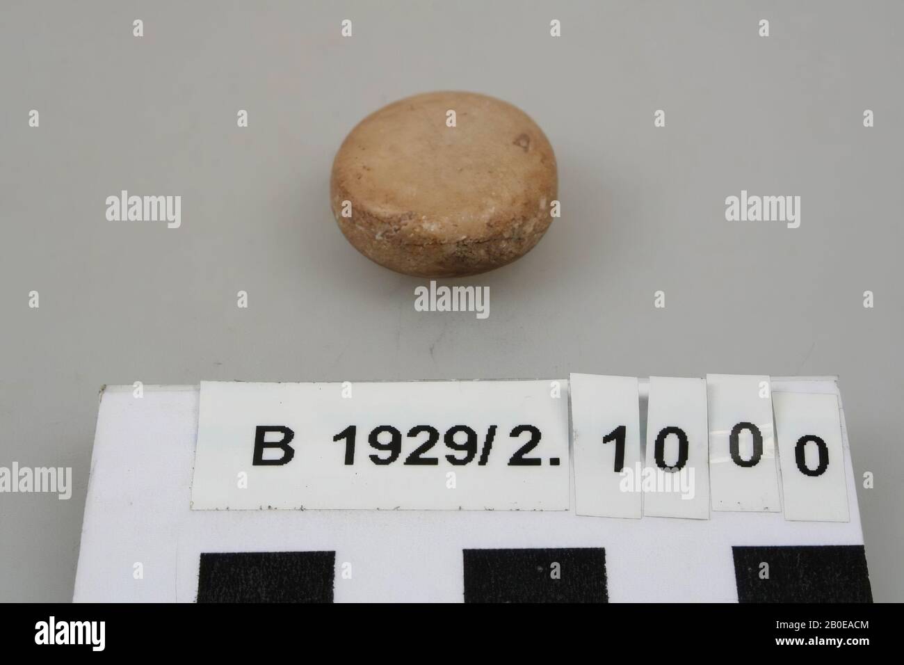 A flat round stone, probably used as a polishing stone, polishing stone ...