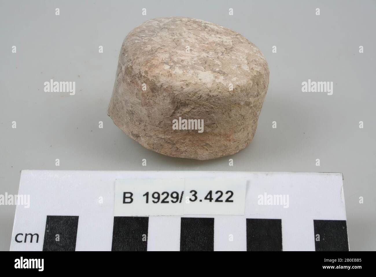 A limestone object in the form of a flattened cylinder. Remains of ...