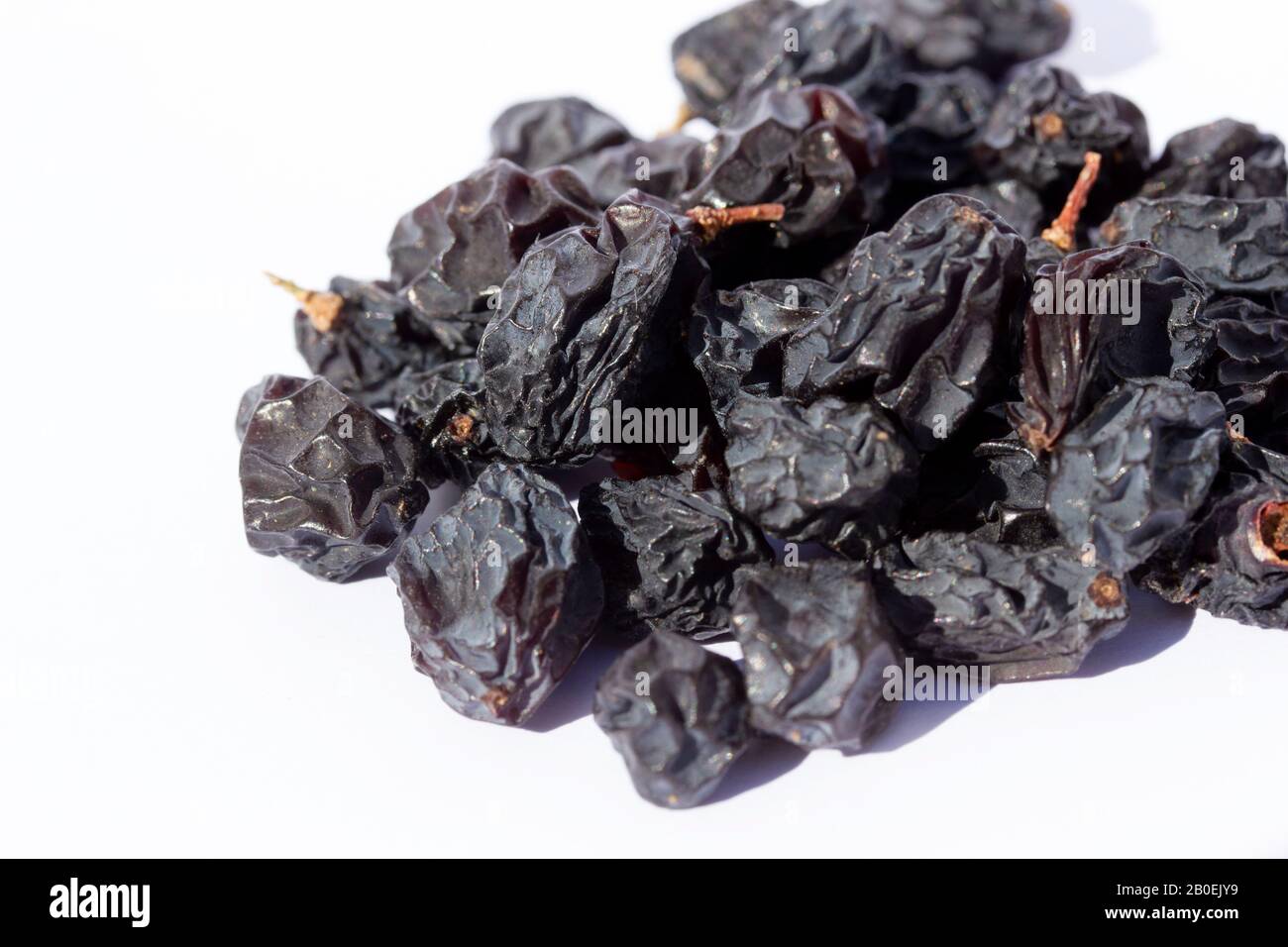 Organic black raisins isolated on a white background Stock Photo - Alamy