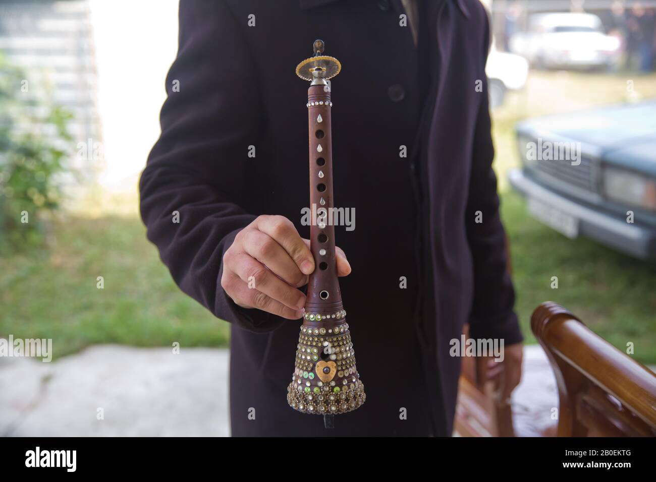 The man was holding a zurna in his hand . A man playing zurna ...