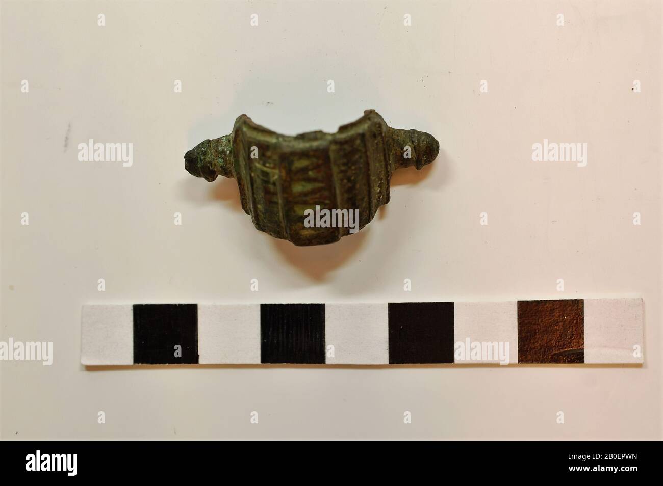 Bronze fibula with remnants of green and red enamel. The pin is missing ...