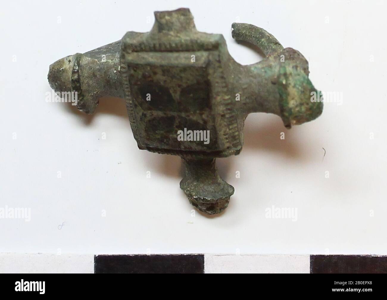 Fibula of bronze. Square disk with four protrusions. Decoration in ...