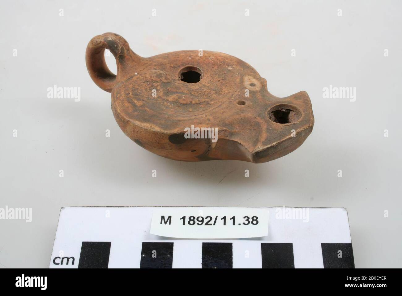 Oil lamp of earthenware, with ear, spout, filling hole, fire hole and a ...