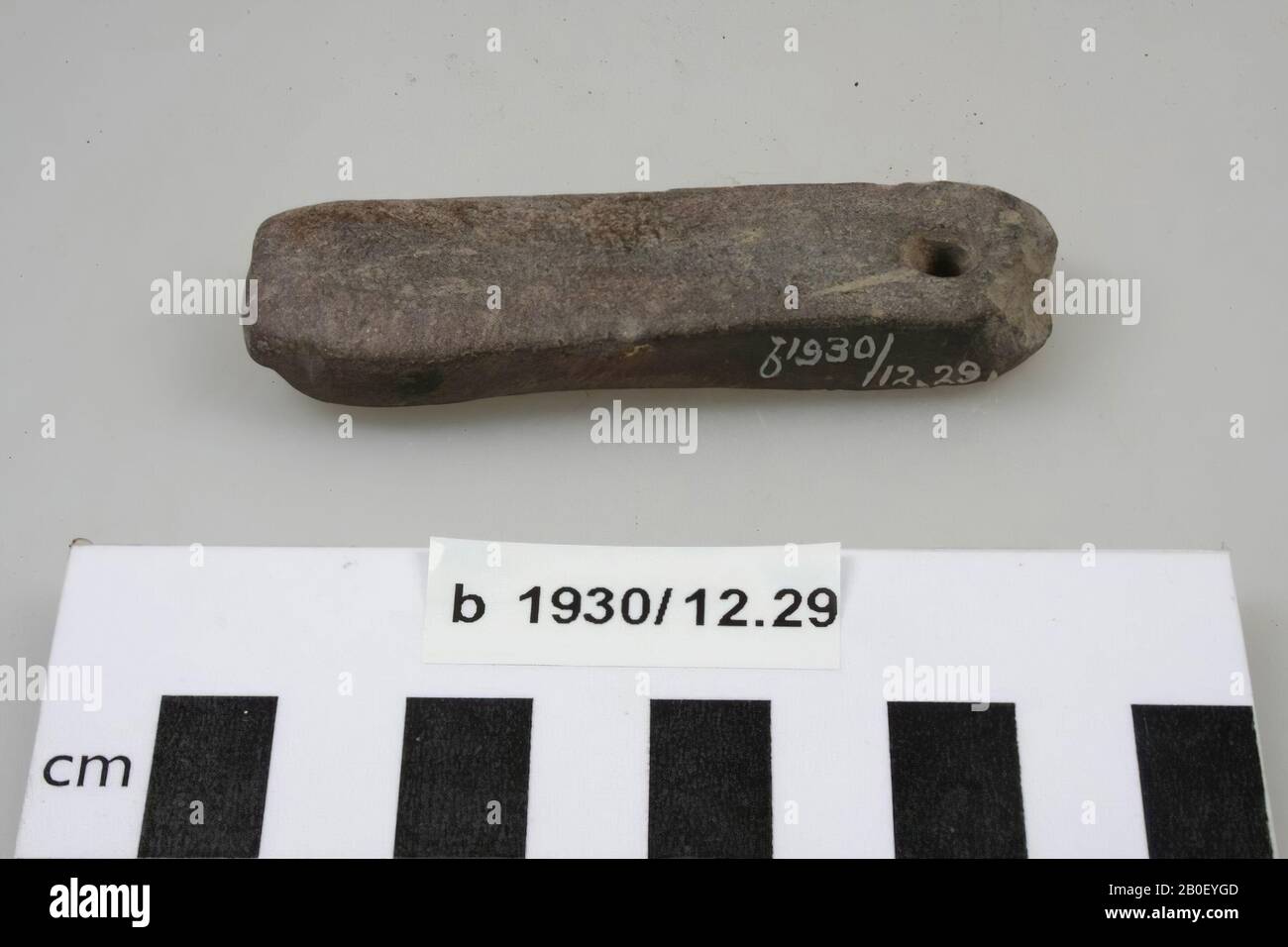 Elongated, pierced grindstone. Parts of both ends are missing ...