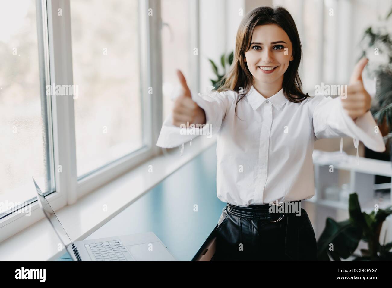 Happy pretty woman showing thumbs up gesture Stock Photo - Alamy