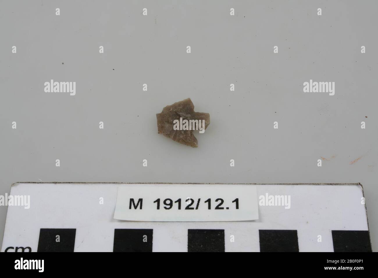 Flint arrowhead, whose tip has been broken off. Chip from the surface ...