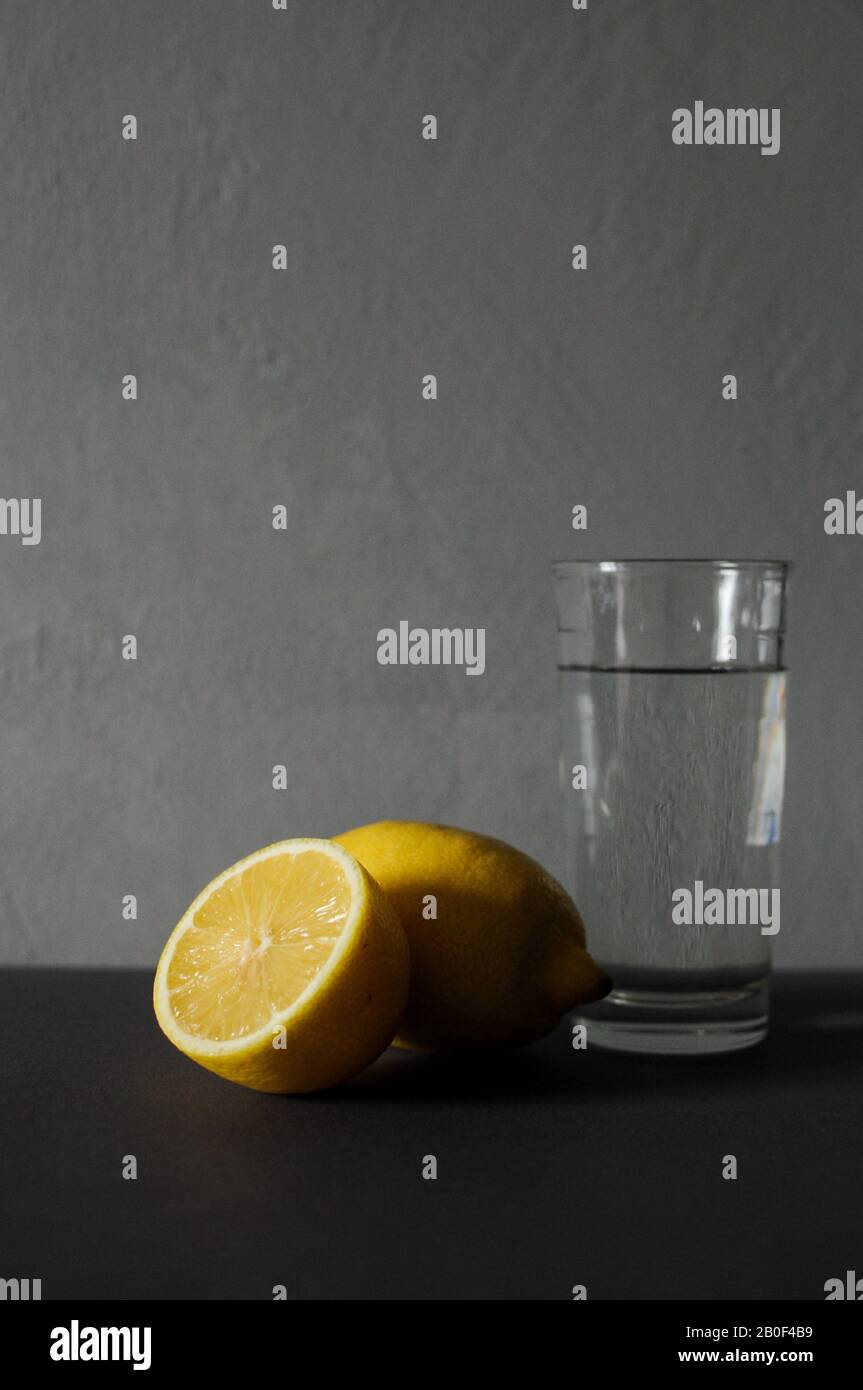 Glass of pure water with slice of lemon on grey background. Morning ...