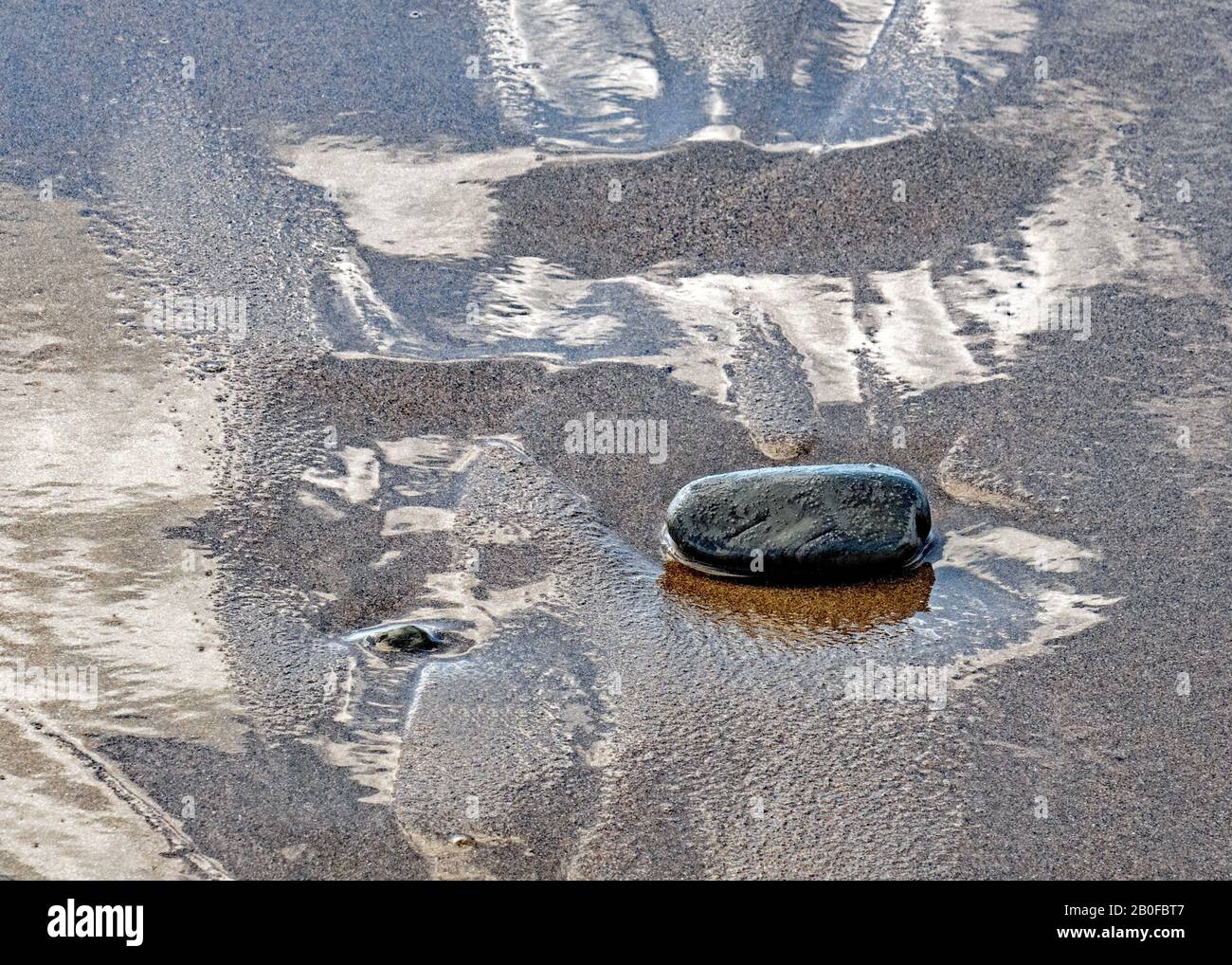 Colour photograph of coastal stones on beach smoothed and rounded by ...