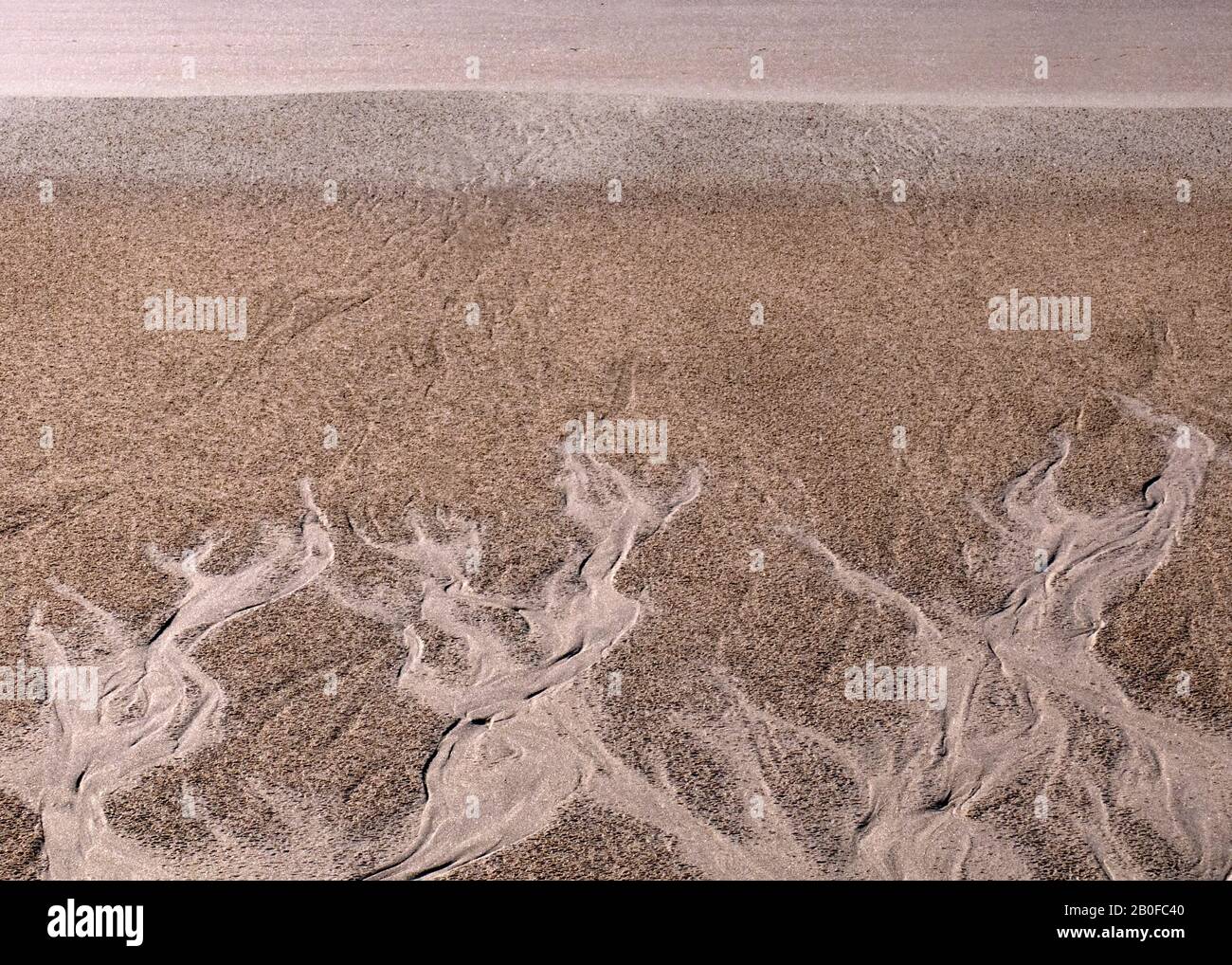 Abstract detailed tidal patterns in the sand at low tide on Penbryn ...