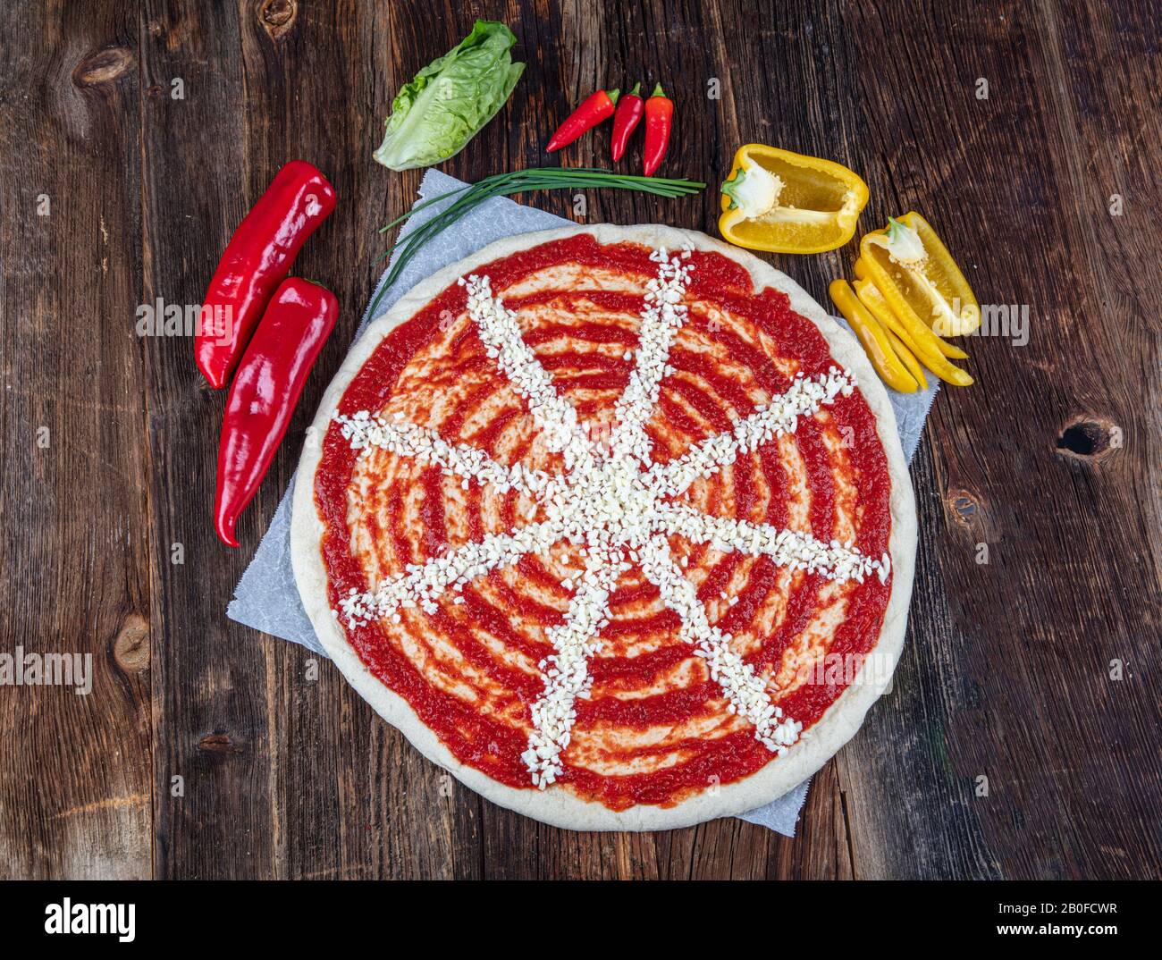 Close-up of Italian pizza preparation. Spreading tomato sauce on pizza ...