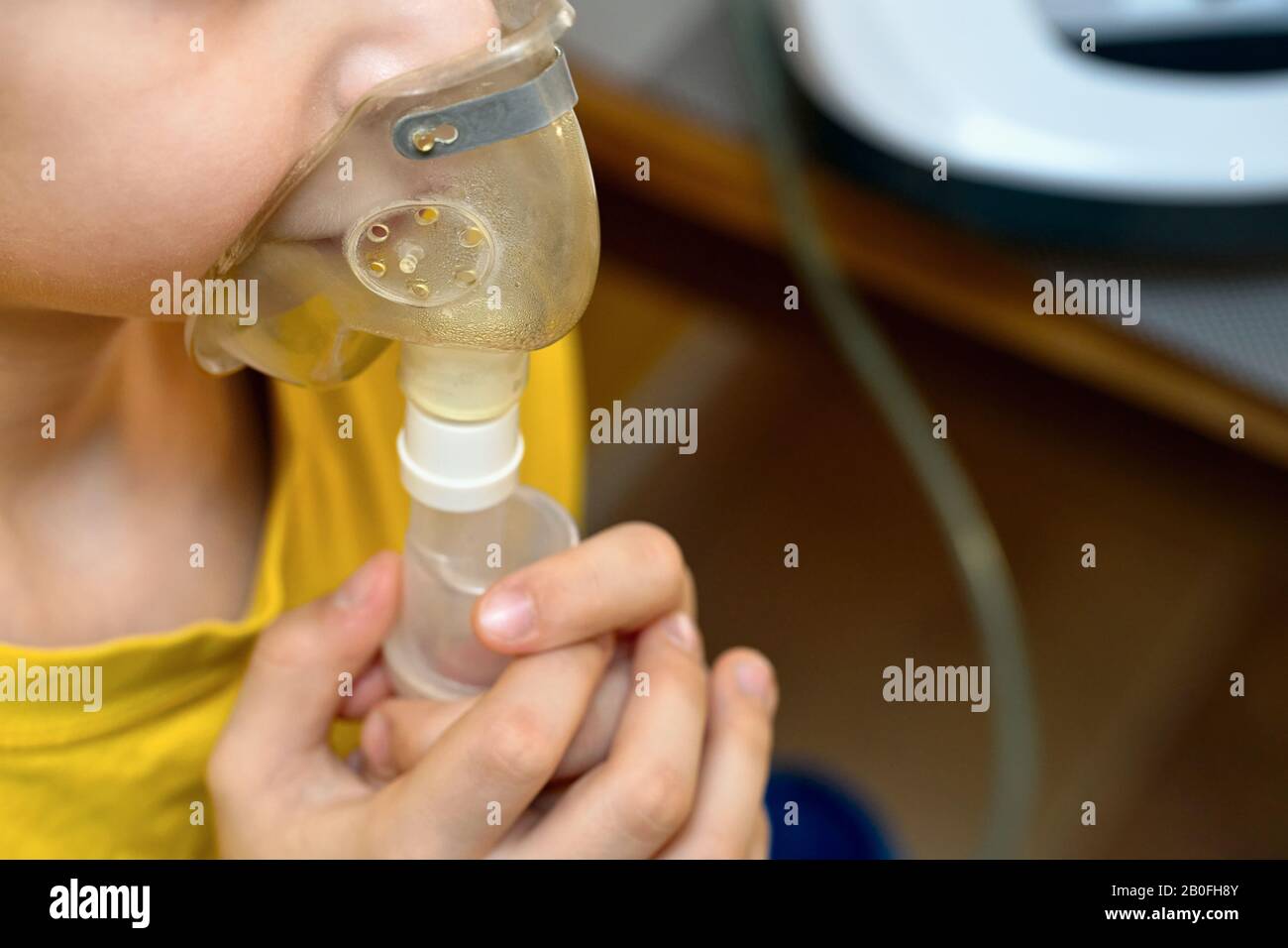 Child makes inhalation at home with nebulizer on out of focus ...