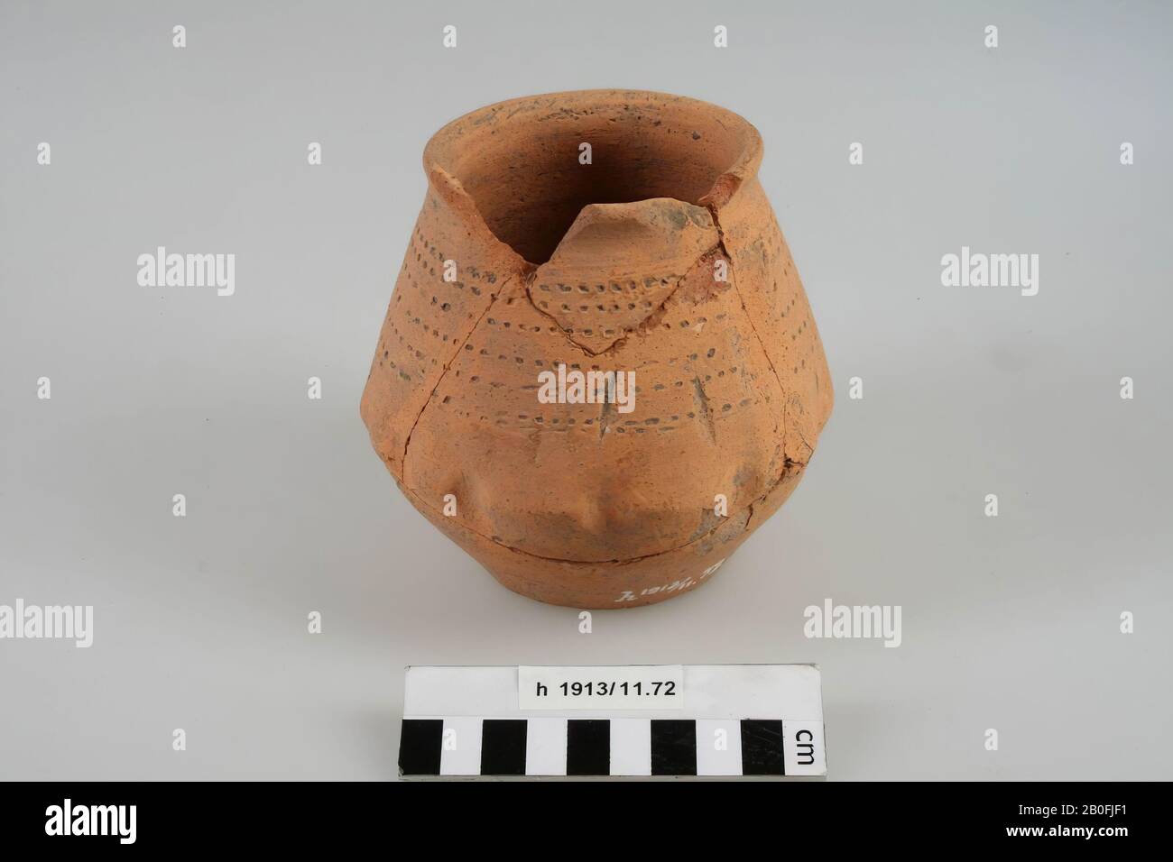 Red pottery jug with vertical indentations. Old bonding, affected ...
