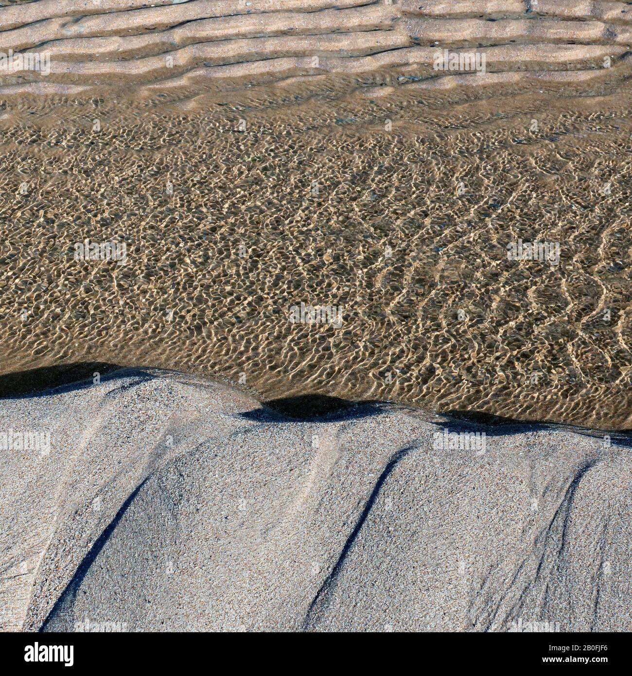 Abstract detailed tidal patterns in the sand at low tide on Penbryn ...