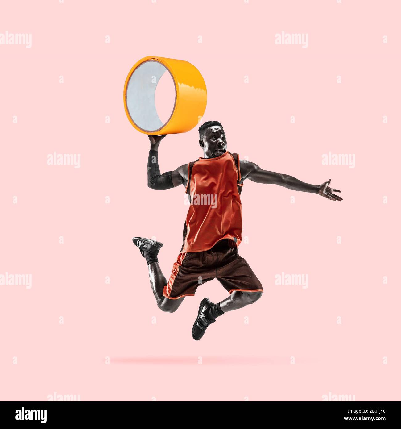 Basketball player with duct tape on coral background. Copyspace for ...