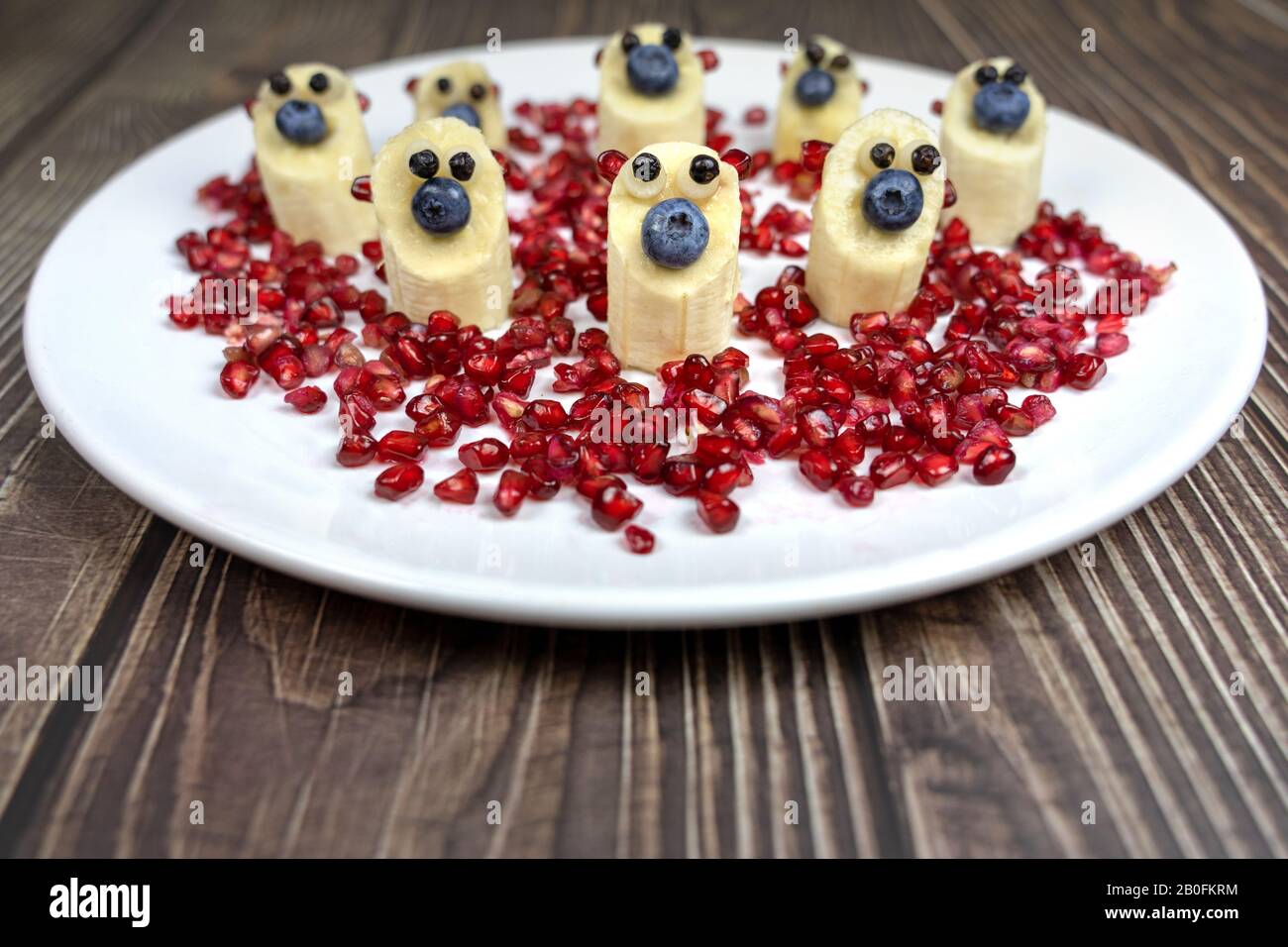 funny little banana bear figures on white plate healthy dessert for ...