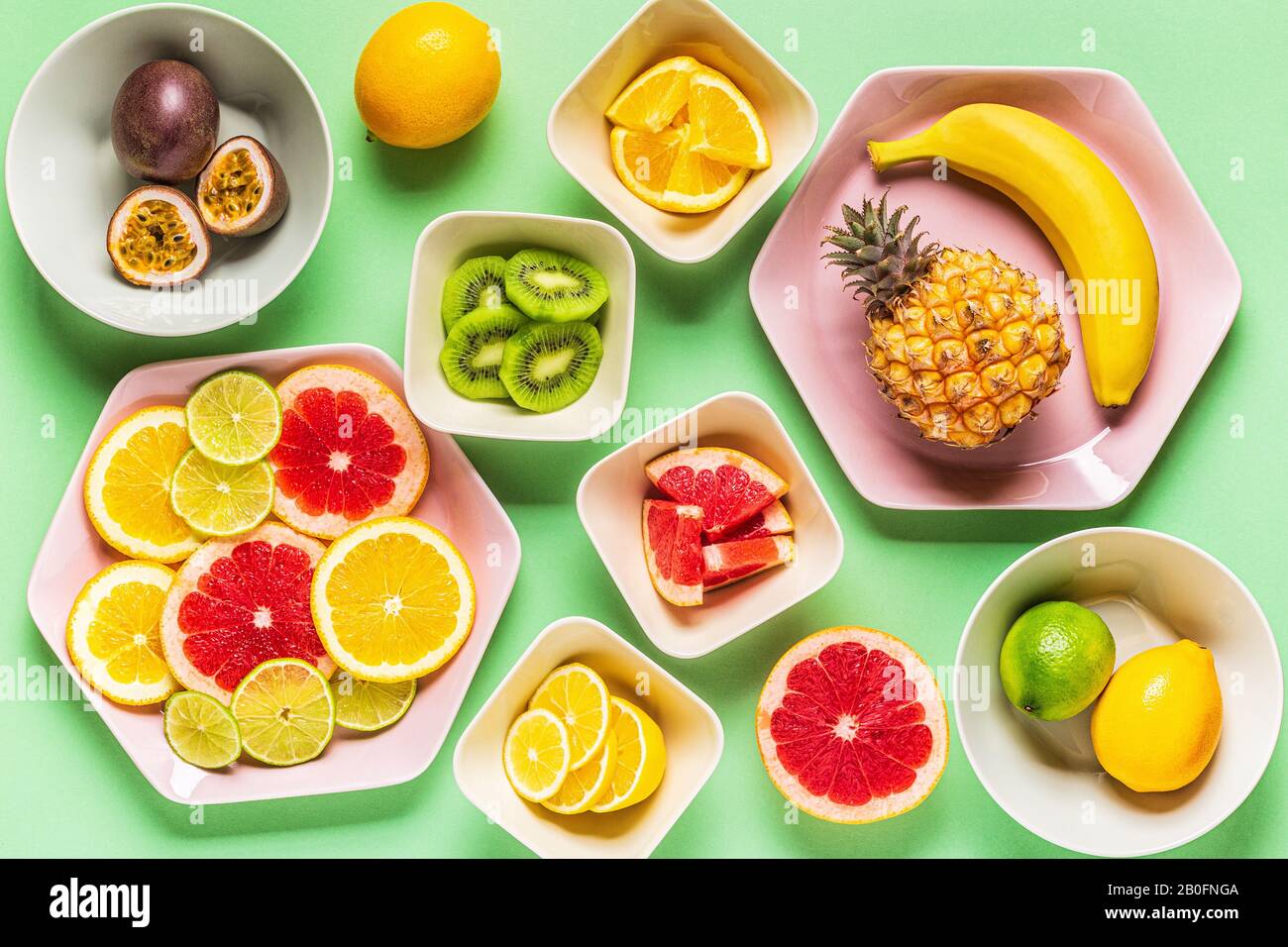 Tropical fruits whole and slices on plates, top view Stock Photo - Alamy