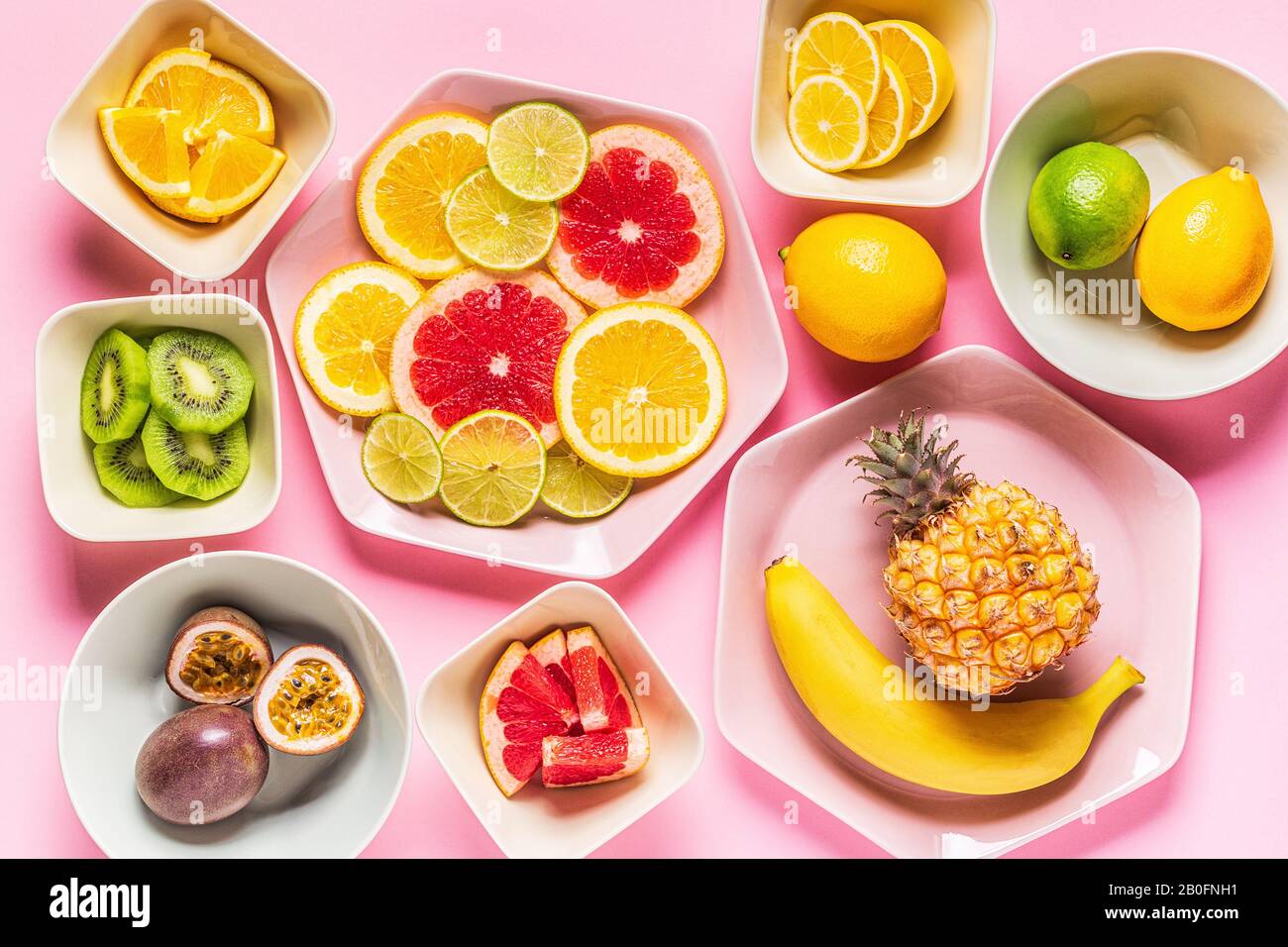 Tropical fruits whole and slices on plates, top view Stock Photo - Alamy
