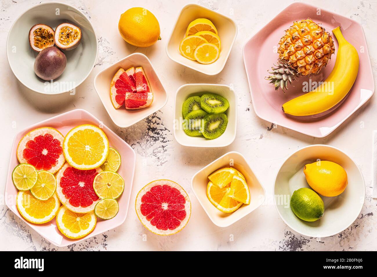 Tropical fruits whole and slices on plates, top view Stock Photo - Alamy