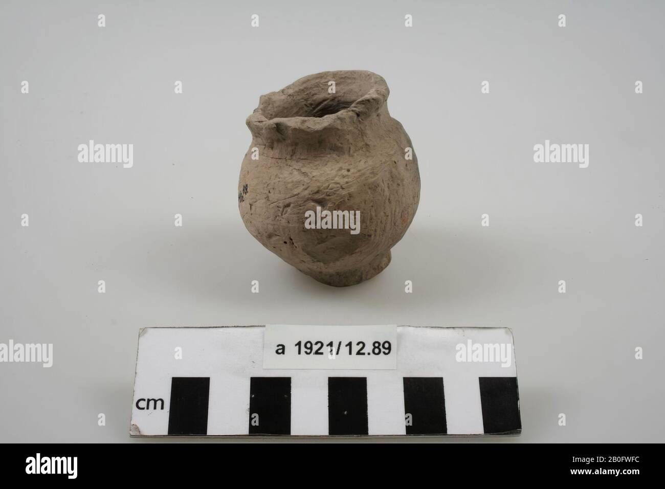 Pot of hand-formed earthenware. Piece of the rim is missing, light ...