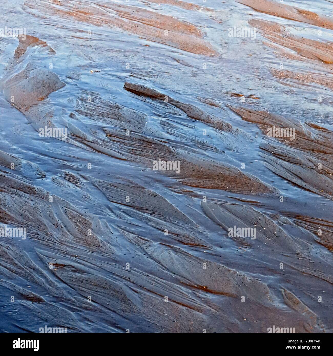 Abstract detailed tidal patterns in the sand at low tide on Penbryn ...