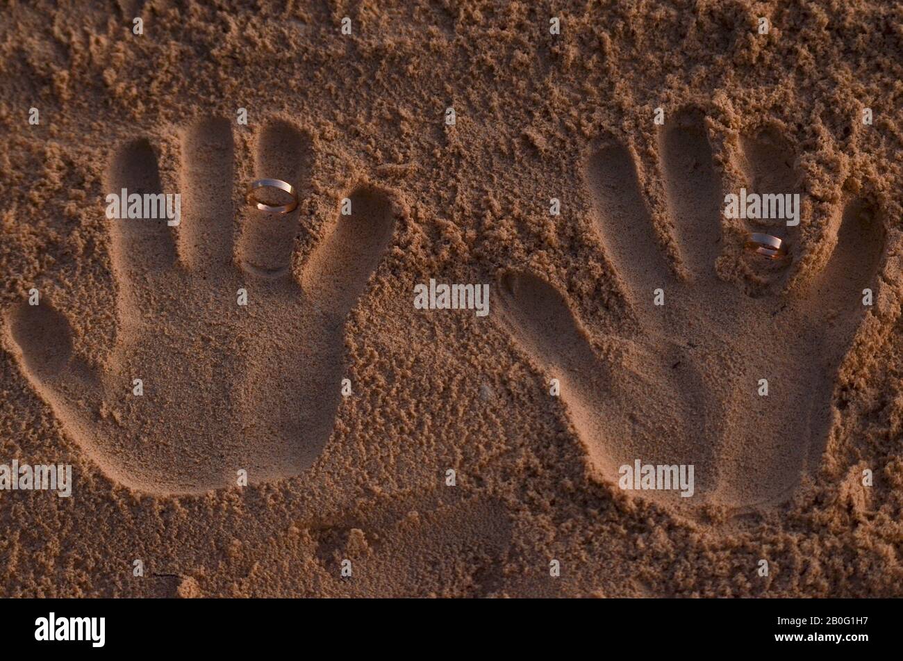 Wedding rings embedded in the sand of the beach 2 Stock Photo - Alamy