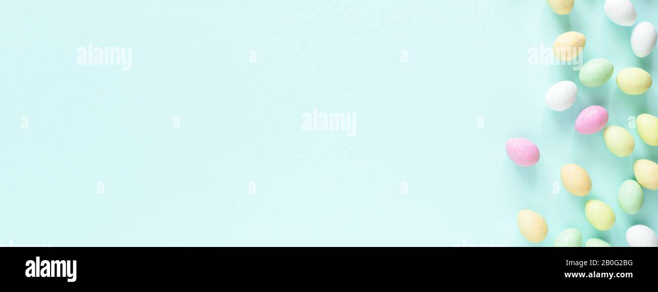 Colored Easter candy eggs on turquoise background. Easter minimal ...