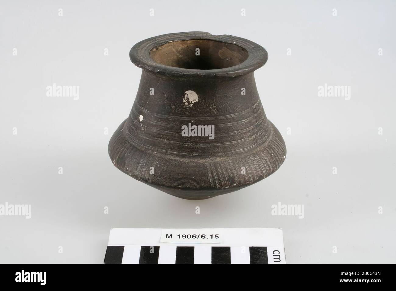 Pot on narrow foot, grooved lines horizontal and vertical. Chip on edge ...