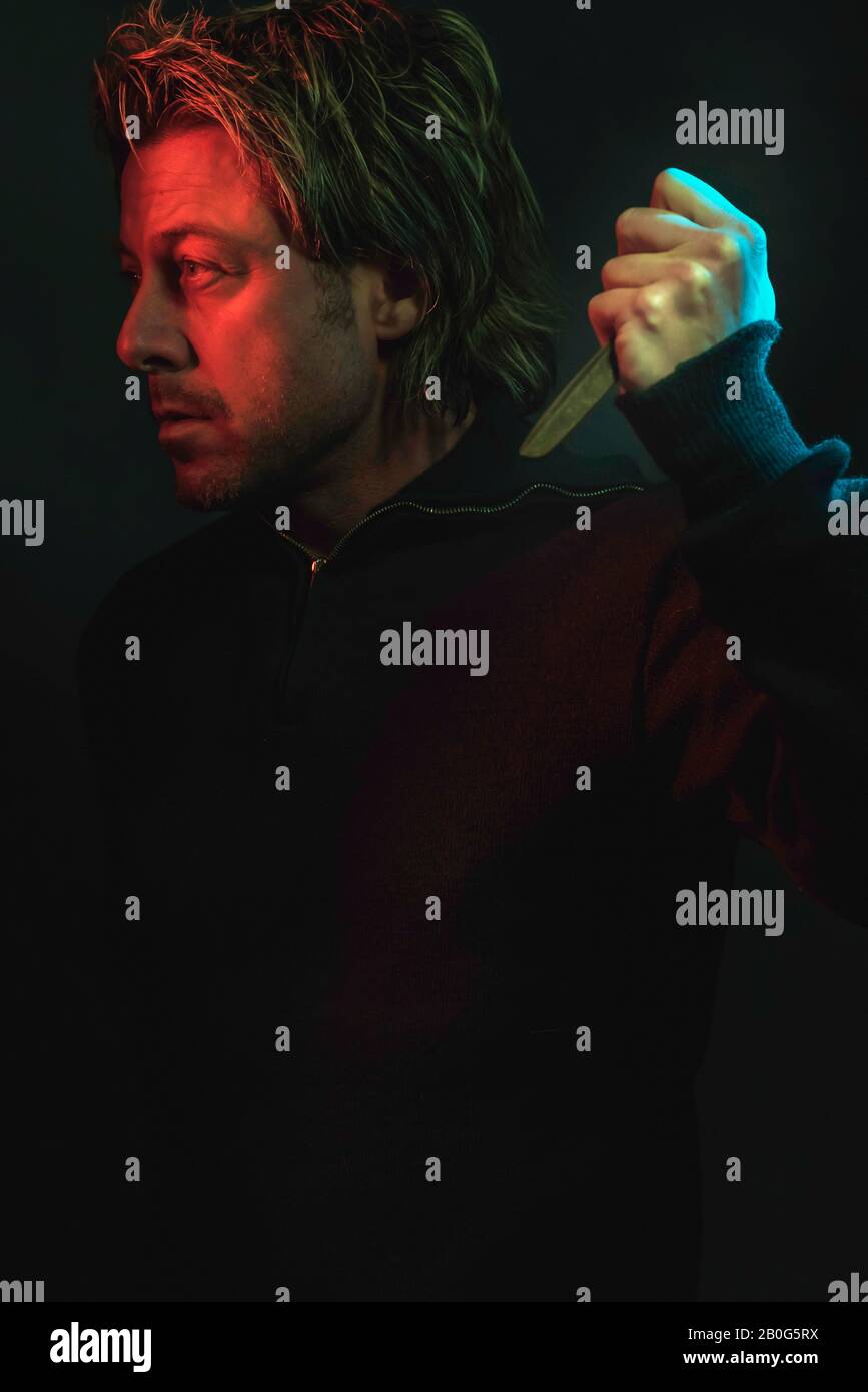 Scary man with scissors in hand illuminated by red and blue light Stock ...