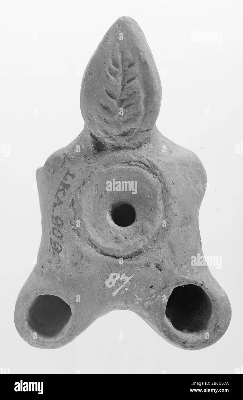 A small oil lamp with two small, rounded spouts with a small round fire ...