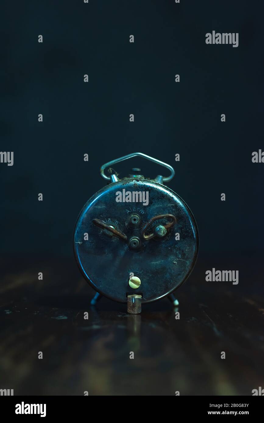 Dusty old alarm clock on worn wooden table. Backside Stock Photo - Alamy