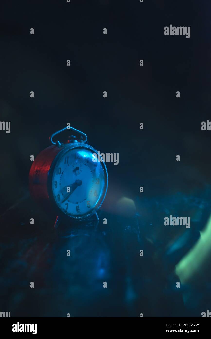 Dusty old alarm clock on worn wooden table at night Stock Photo - Alamy