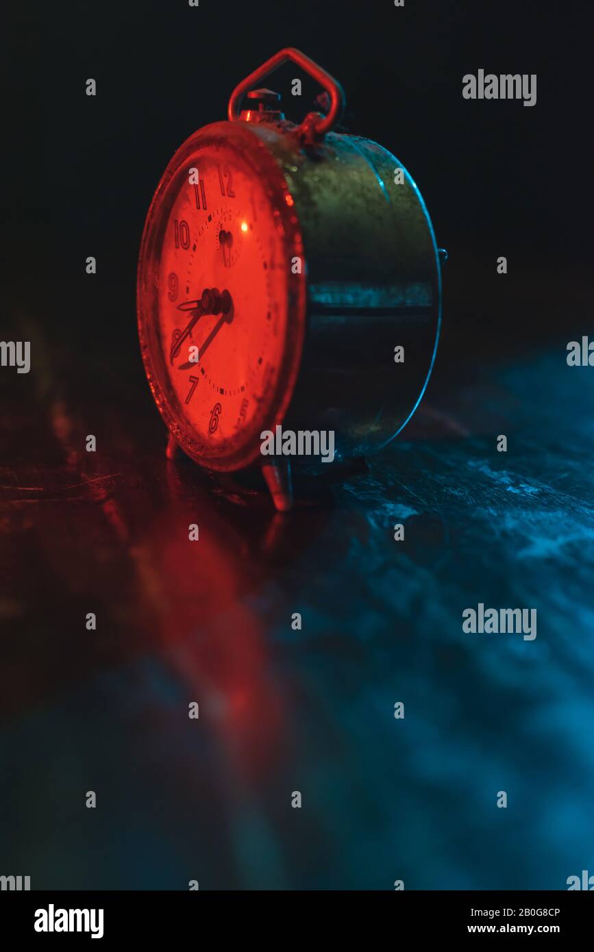 Dusty old alarm clock on worn wooden table at night Stock Photo - Alamy