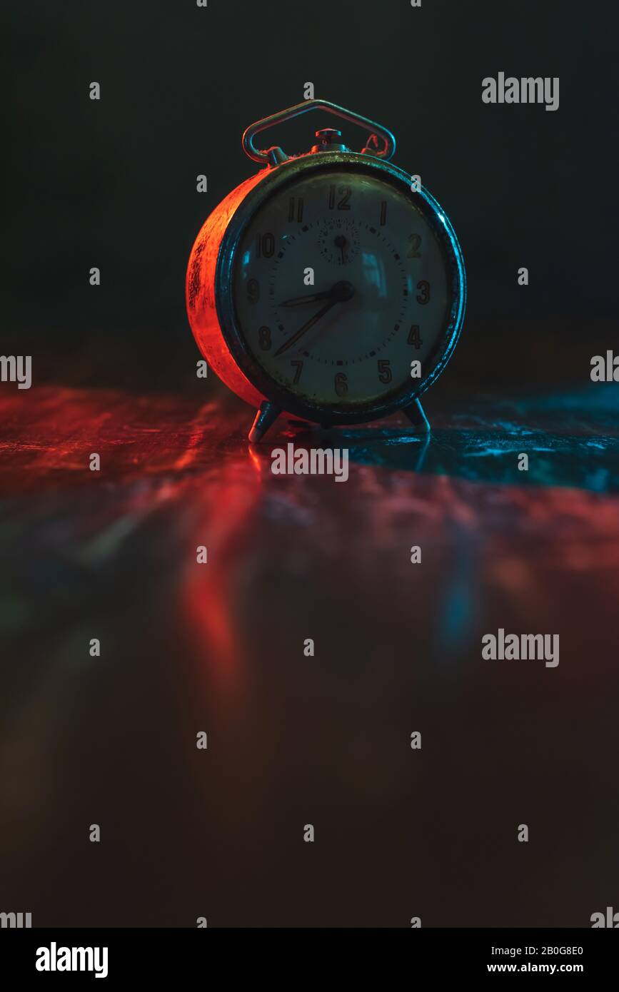 Dusty old alarm clock on worn wooden table at night Stock Photo - Alamy