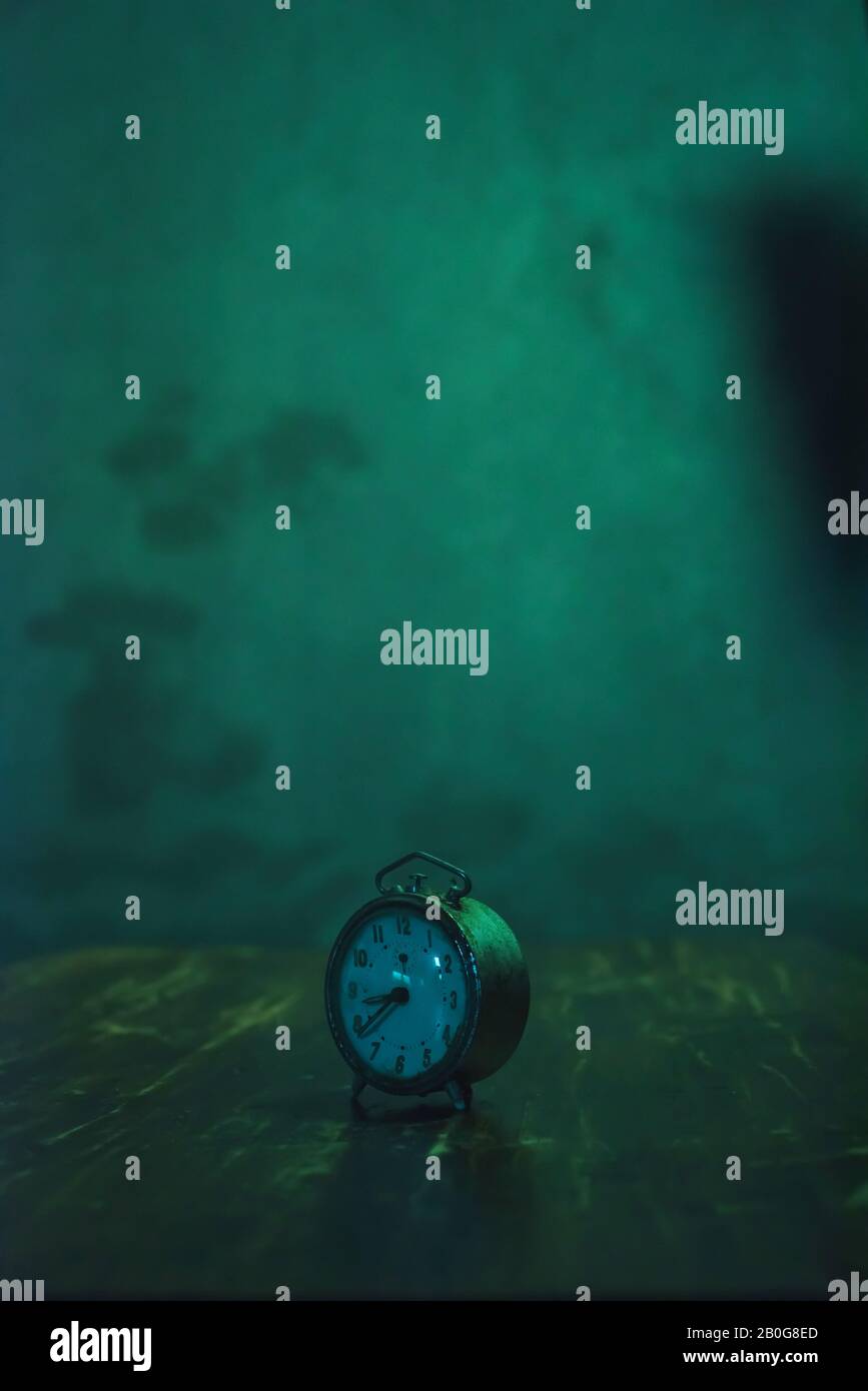 Dusty old alarm clock on worn wooden table Stock Photo - Alamy