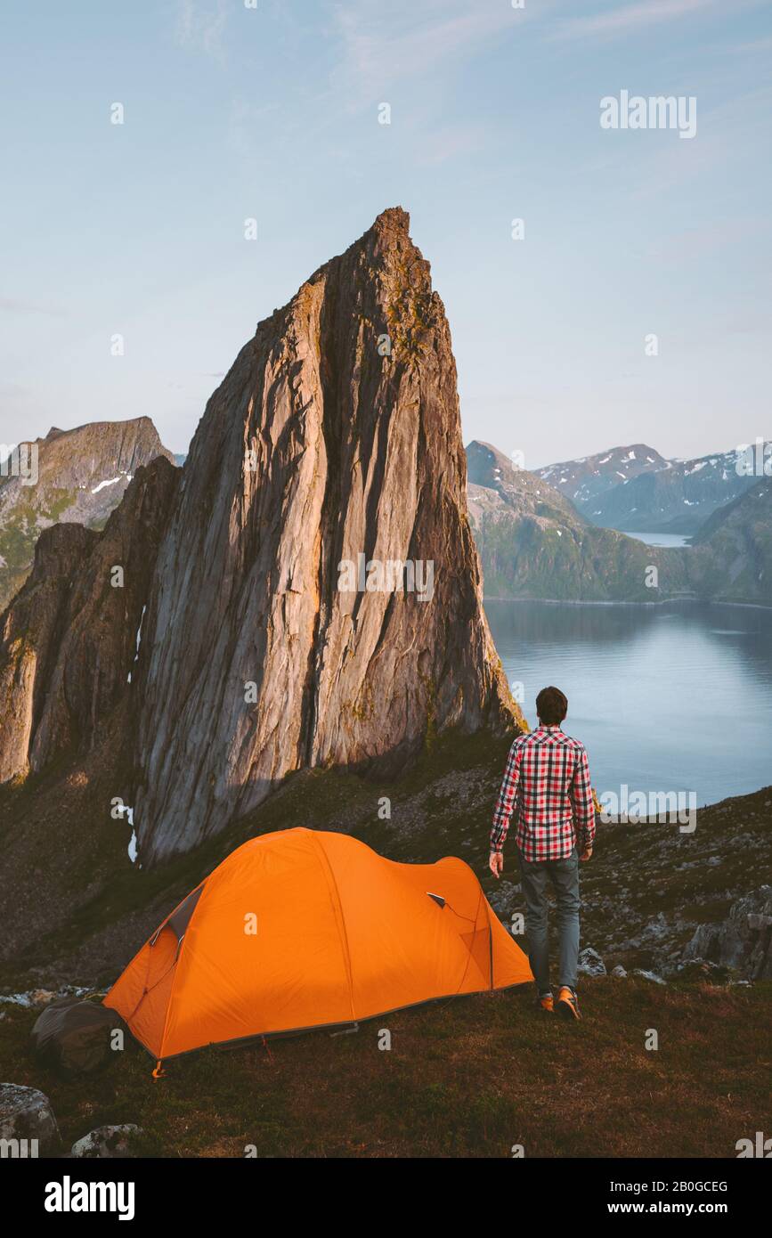 Camping tent and man solo traveler hiking in Norway sustainable travel ...