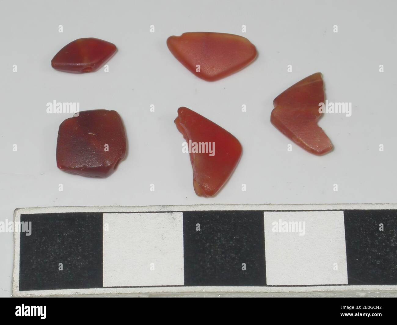 5 red, diamond-shaped beads. Varying in size. 3 are broken in half ...