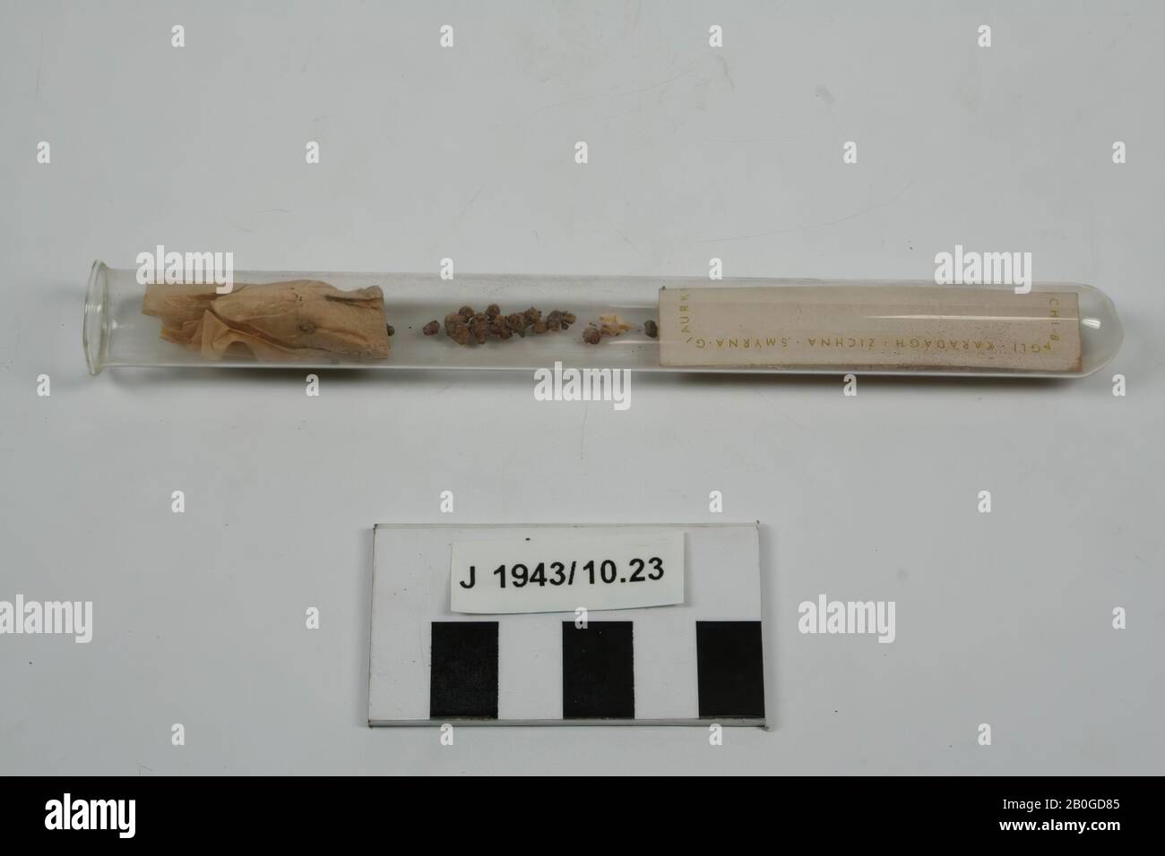 Glass test tube with soil sample and note with text: ro. ar. color ...