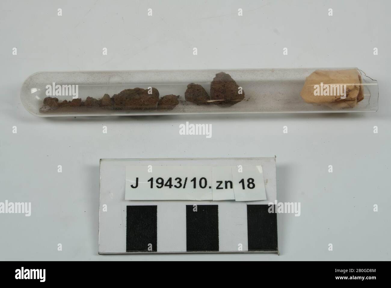 Glass test tube with fragments of stone. The test tube is broken under ...