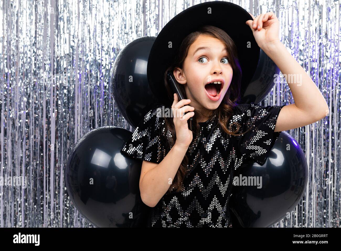 joyful european teen girl communicates on the phone at a party with a ...